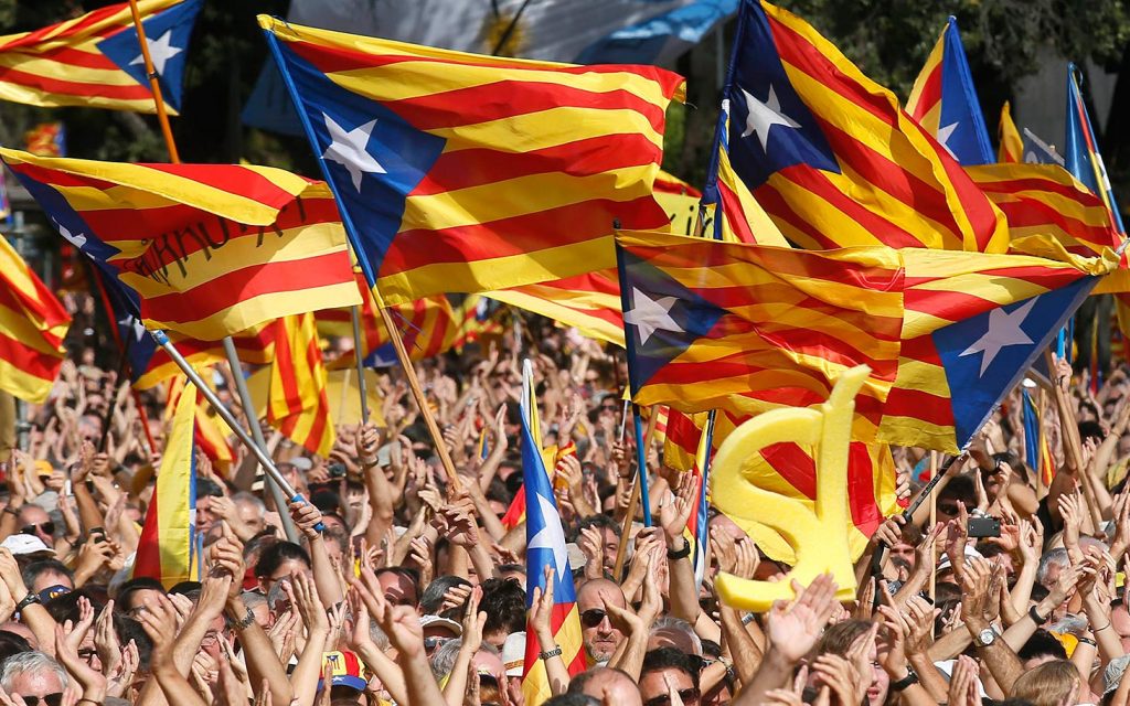 People wave their "Esteladas" (Catalonian separatist flag) flags during ...